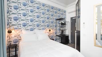 Quarto com uma cama, duas mesas de cabeceira, um guarda-roupa e um espelho.