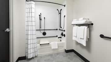 Uma casa de banho moderna com chuveiro, banheira e porta-toalhas.