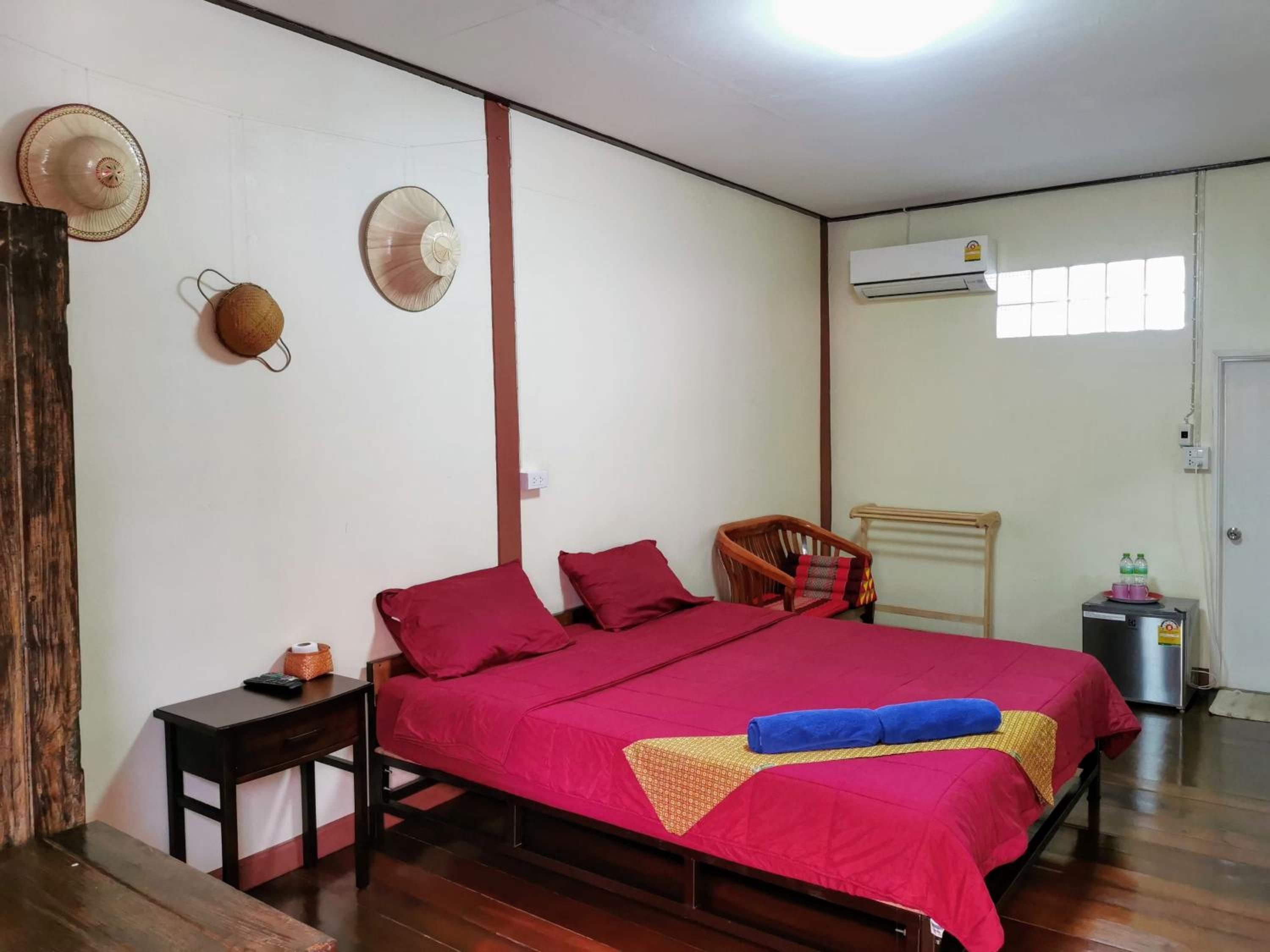 Quarto com cama, mesa de cabeceira, cadeira, aquecedor e ar condicionado.