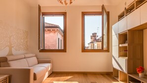Quarto moderno com sofá, piso de madeira e armário embutido em madeira.