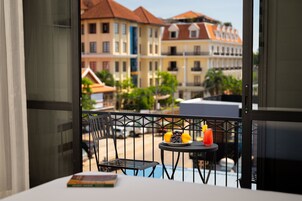 Uma varanda com mesa, cadeira e vista para edifícios.