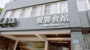 Um hotel com uma placa que diz 'ISING HOTEL' em inglês e caracteres chineses.