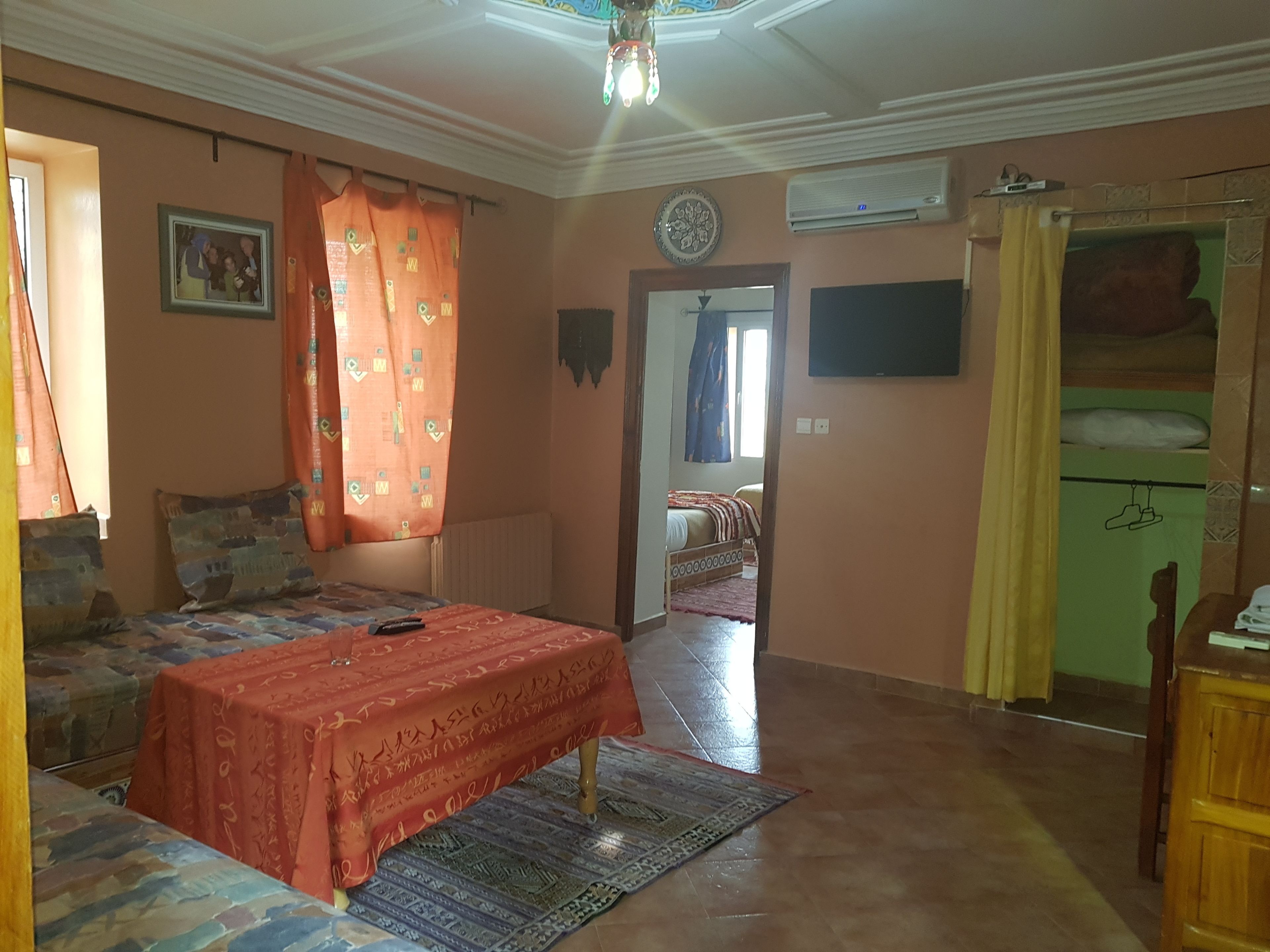 Um quarto com cama, mesa, cadeira e guarda-roupa.