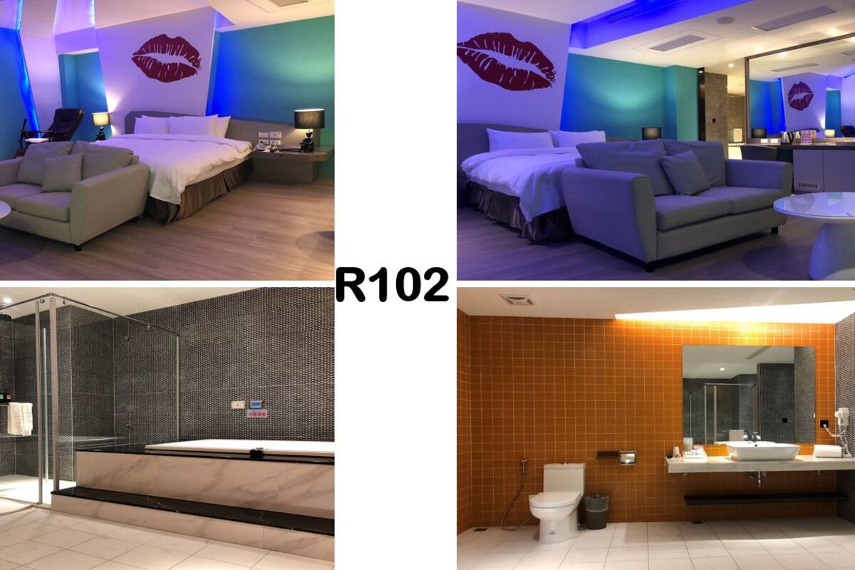 Quarto de hotel com cama, sofá, mesa pequena e banheiro com chuveiro, vaso sanitário e pia.