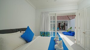 Quarto de hotel com uma cama, uma toalha azul e vista para a área da piscina.