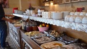 Um buffet com diversos alimentos e utensílios.