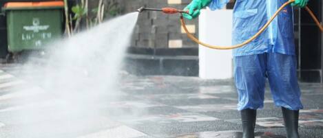 Uma pessoa com equipamento de proteção pulverizando água.