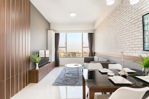 Uma sala de estar moderna com área de jantar, janelas amplas e vista para a cidade.