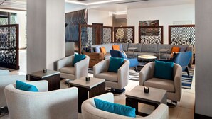 Uma área de estar moderna com sofás, poltronas e mesas.
