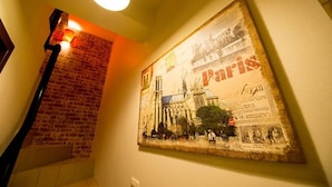 Uma escadaria com uma parede de tijolos e um cartaz de Paris na parede.