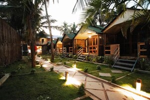 Um resort com diversas acomodações tipo bangalô, cada uma com uma escadaria que leva à entrada.