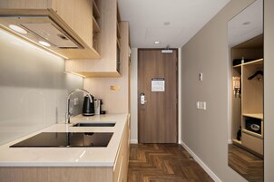 Uma cozinha moderna com uma pia dupla, cafeteira e um aviso indicando a área de refeições.