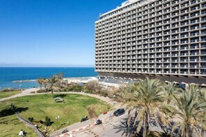 Um hotel grande com várias varandas com vista para a praia e o oceano.