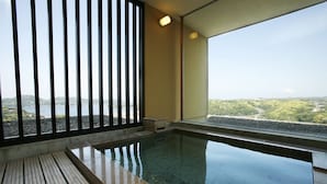 Piscina interior moderna com vista para uma ponte e vegetação.