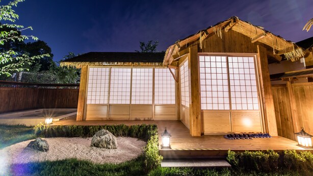 Um edifício tradicional em estilo japonês, com fachada de madeira e portas deslizantes.
