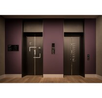 Três portas de elevador com indicadores de andar, placas de rota de fuga de emergência e um letreiro de lounge de recepção.