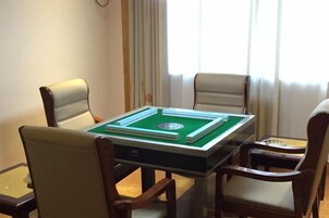 Quarto com mesa de bilhar, quatro cadeiras e janela com cortinas.