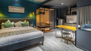 Quarto moderno com cama, mesa de cabeceira e escrivaninha com cadeiras.
