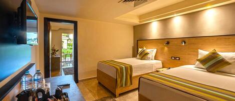 Quarto de hotel com duas camas, televisão, máquina de café e mini-bar.