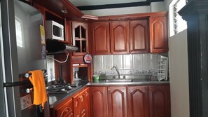 Um frigorífico, um micro-ondas, um forno, uma placa de cozinha 