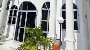 Um edifício com várias andares, colunas brancas e janelas em arco.