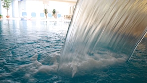 Uma grande cascata interior com um tanque de água em primeiro plano.