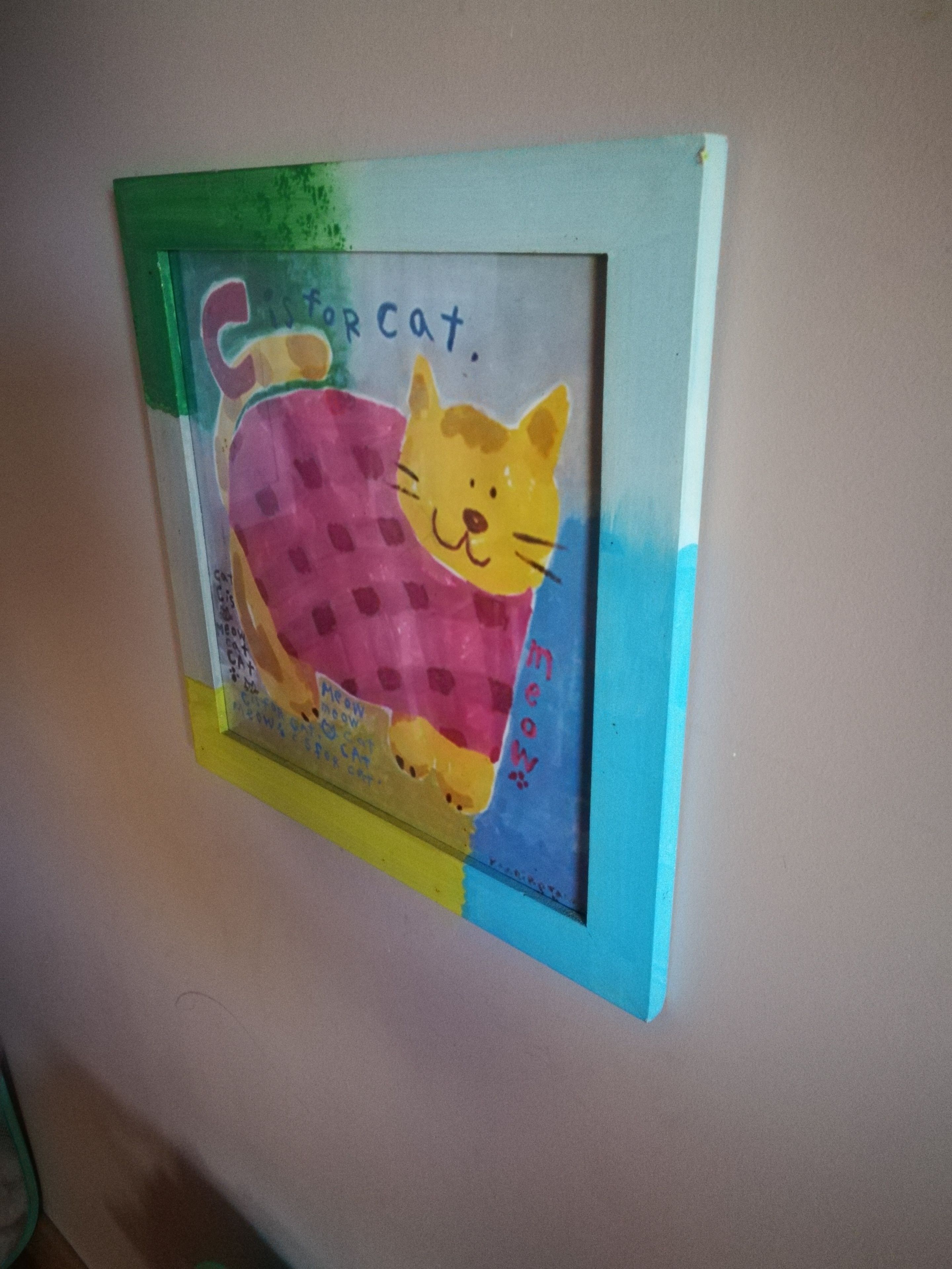 Uma obra de arte emoldurada de um gato na parede.