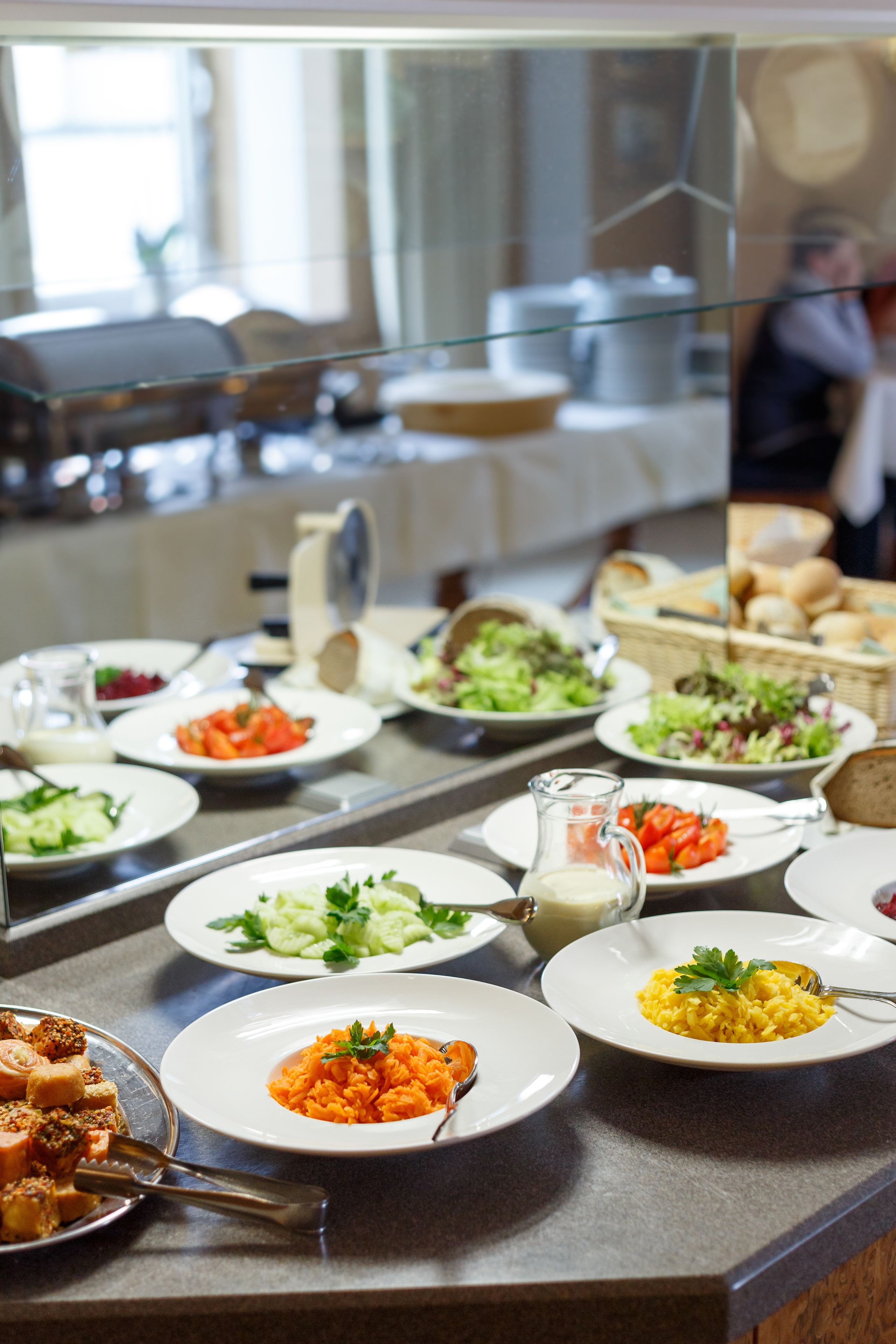 Buffet com diversos pratos, incluindo saladas, legumes e arroz.