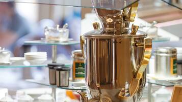 Uma máquina de café em uma bancada, com uma vitrine de vidro ao fundo.