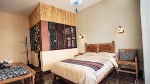 Quarto com cama, cabeceira de madeira, uma mesinha e uma cadeira.