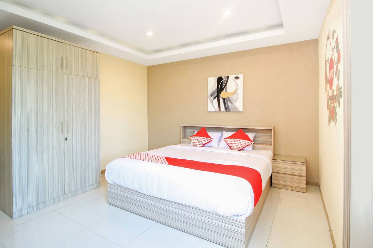 Quarto com cama, guarda-roupa e um quadro na parede.