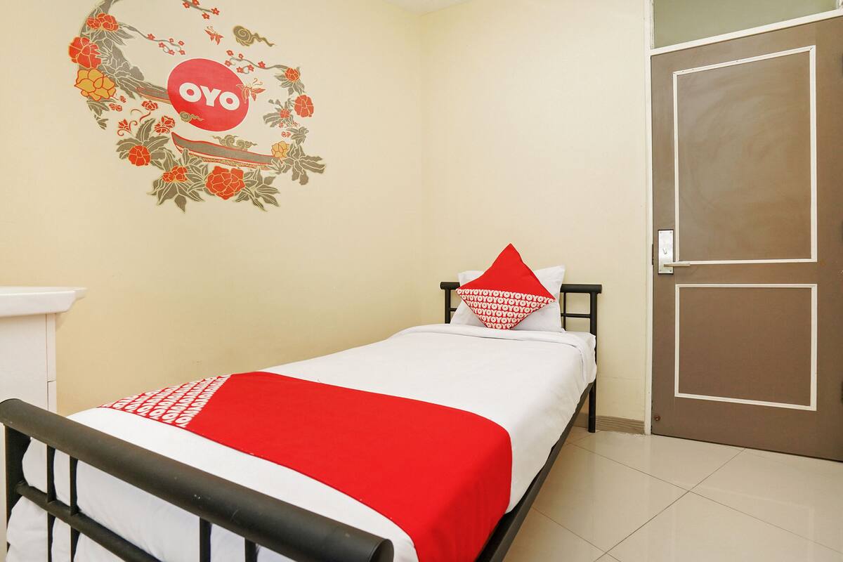 Quarto de hotel com cama, decoração na parede e porta.