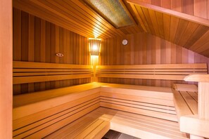 Uma sauna com bancos de madeira e um acessório de iluminação fixado na parede.
