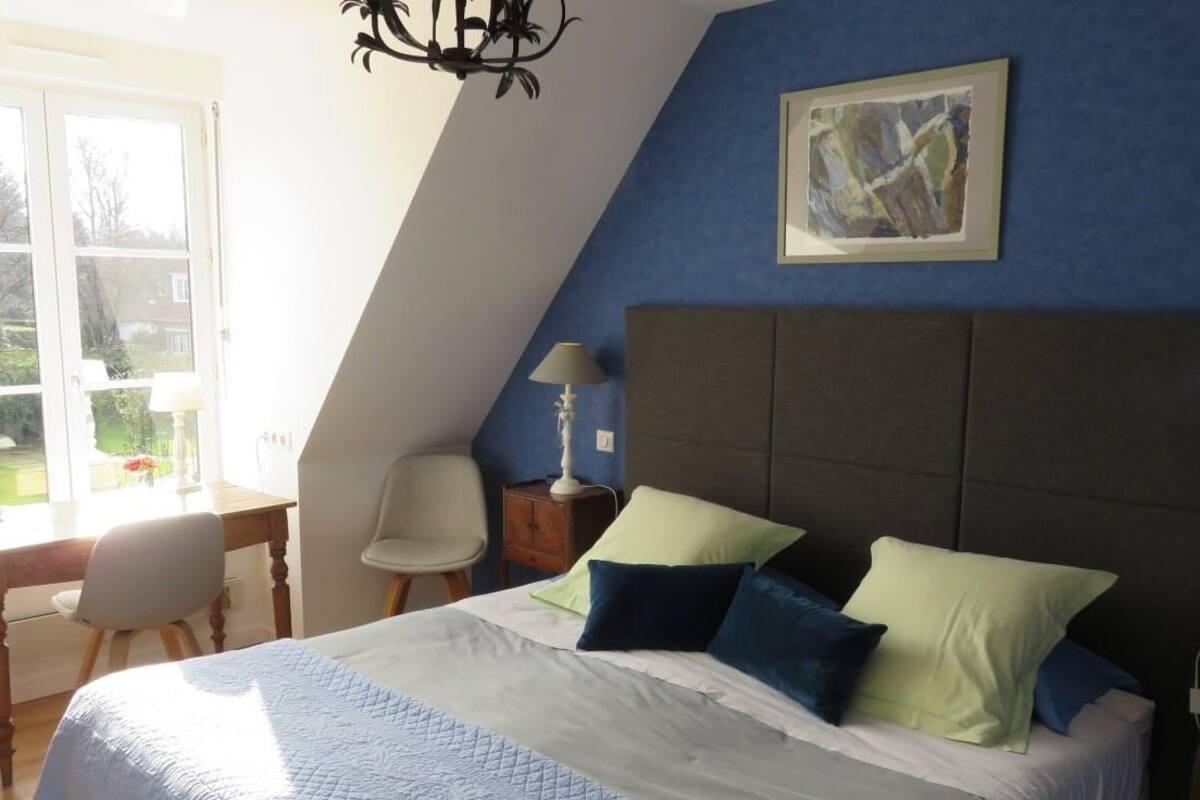 Quarto com cama, escrivaninha e cadeira.