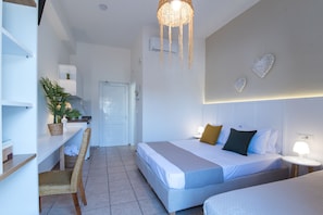 Quarto de hotel moderno com uma cama grande, mesas de cabeceira, uma escrivaninha e uma cadeira.