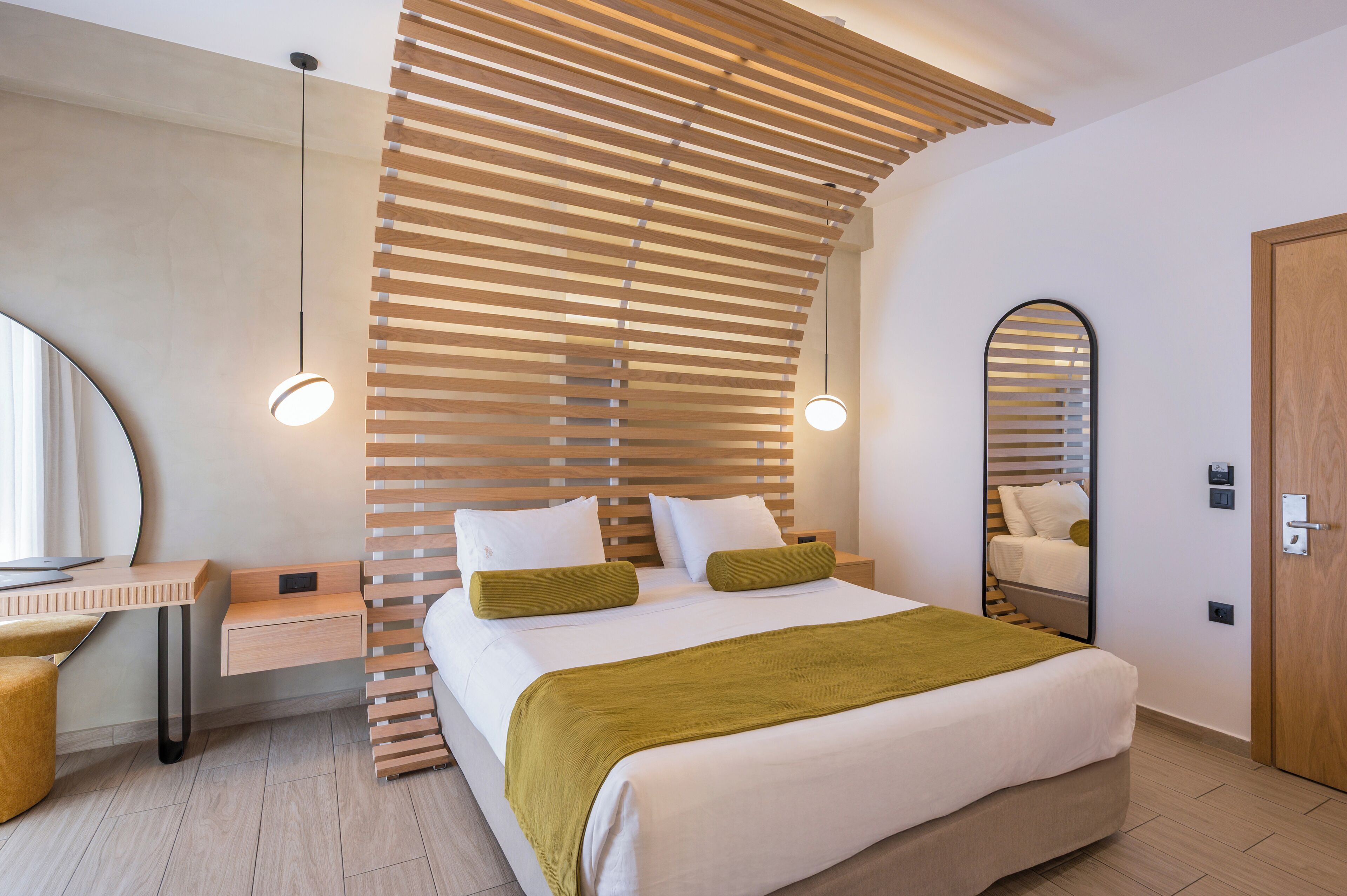 Quarto moderno com cama, mesa de cabeceira e espelho.