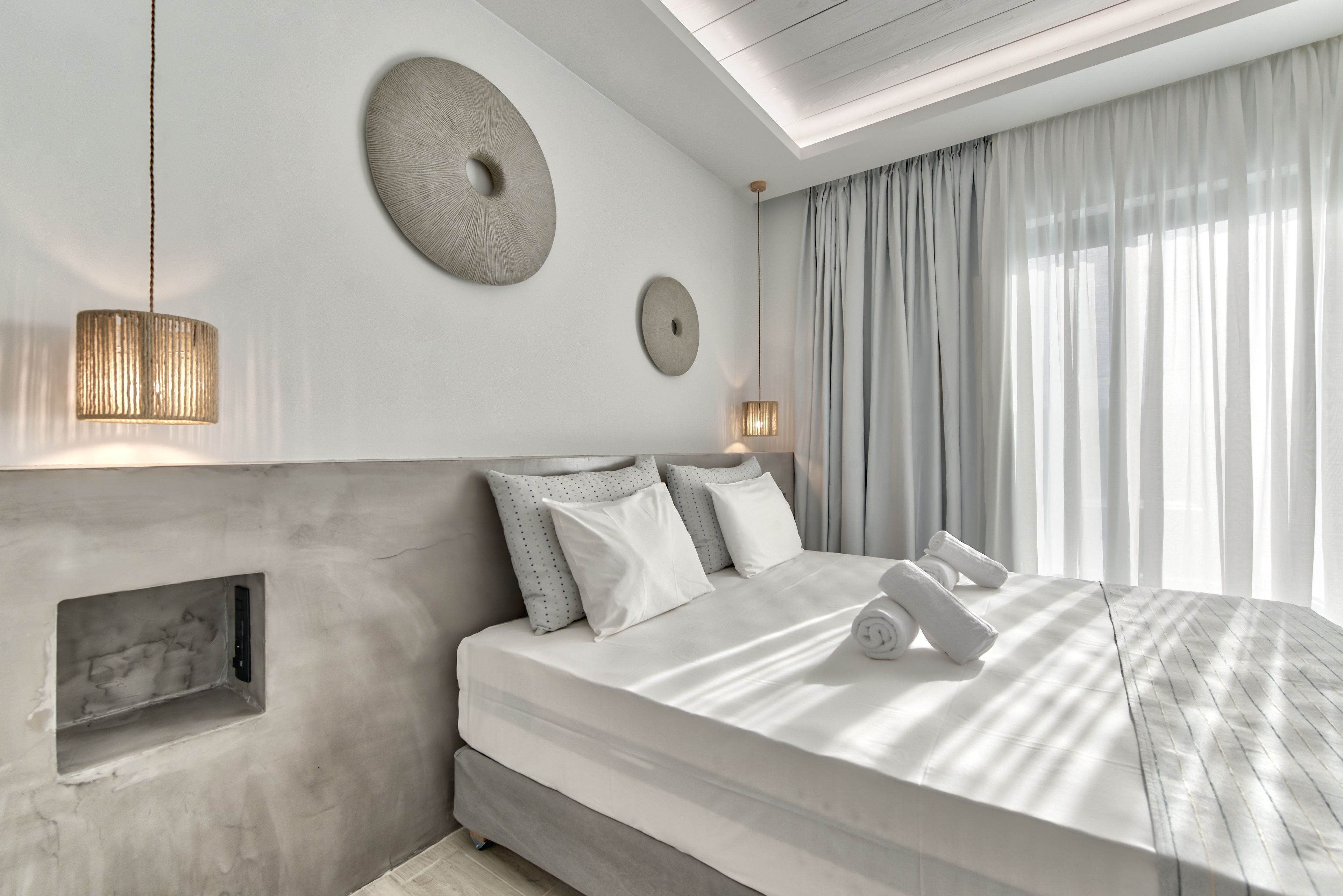 Quarto moderno com cama grande, claraboia e vista para o exterior.