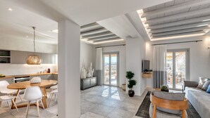 Um espaço de estar moderno com área de jantar, sofá e cozinha.