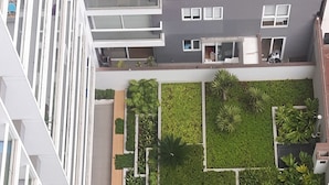 Vista aérea de um edifício residencial com piscina, áreas verdes e design arquitetônico moderno.