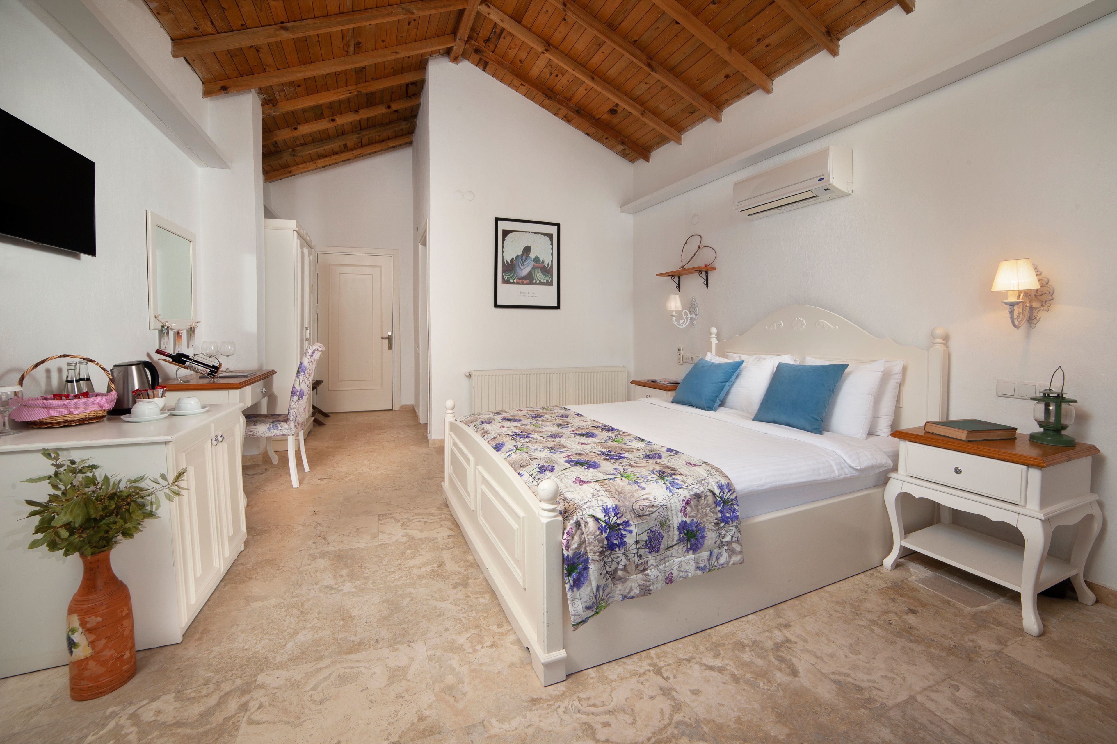 Quarto com cama, mesa de cabeceira, abajur e espelho.