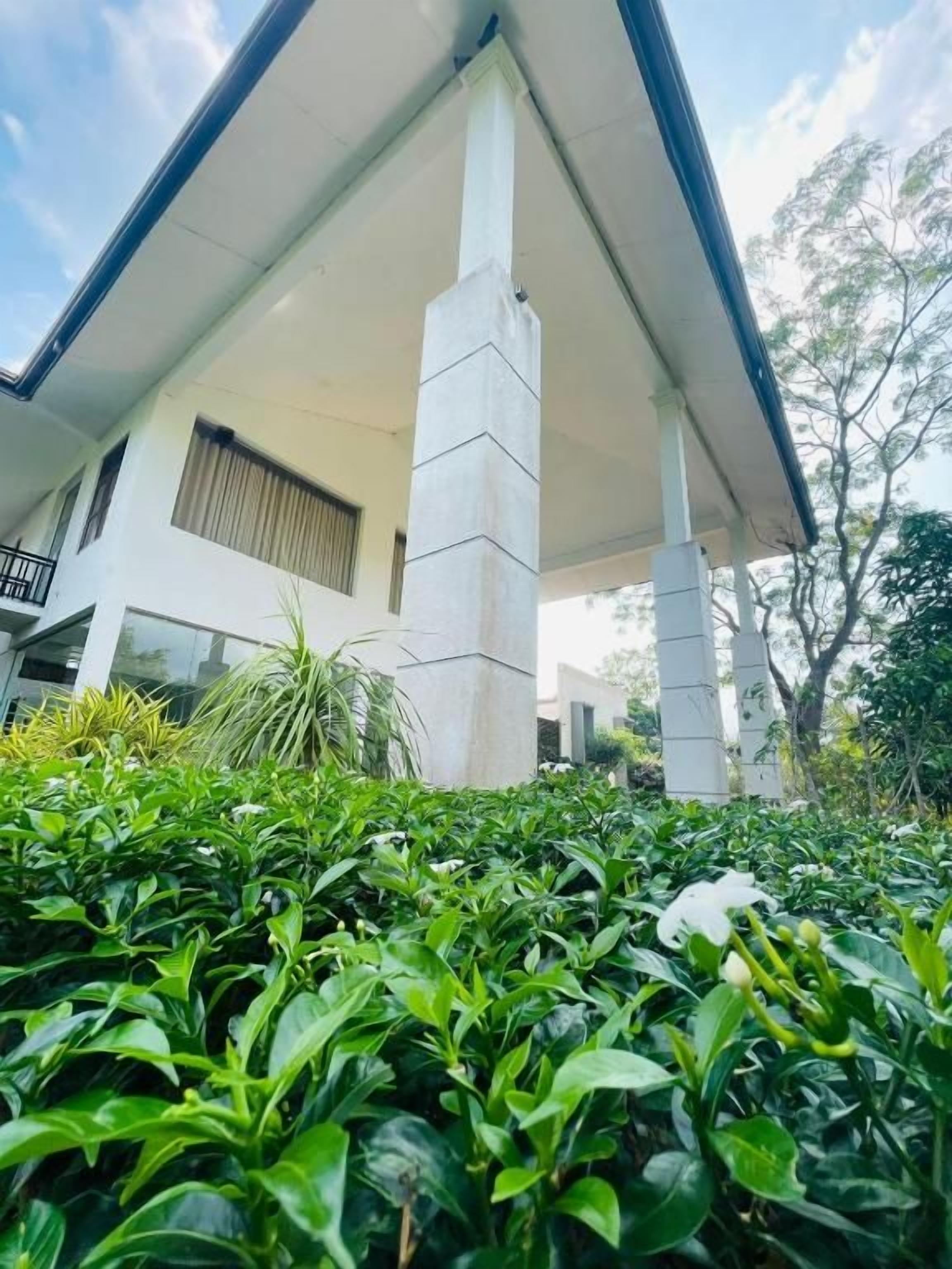 Um edifício moderno com teto plano, amplas janelas e um pilar de concreto.