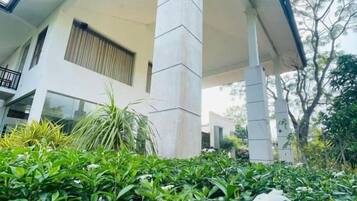 Um edifício moderno com teto plano, amplas janelas e um pilar de concreto.
