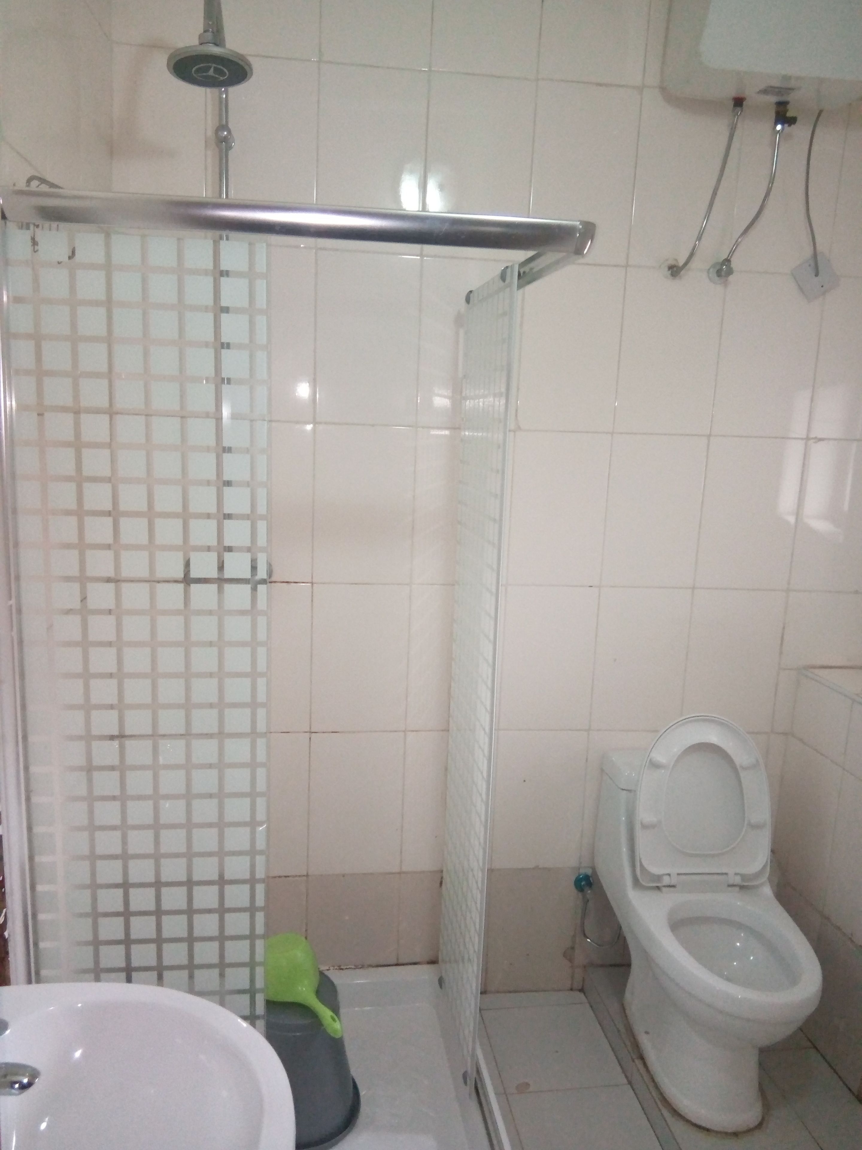 Casa de banho com chuveiro, sanita e lavatório.