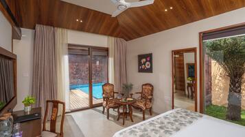 Quarto espaçoso com uma cama grande, uma mesa de jantar com cadeiras, uma piscina pequena e vista para o exterior.