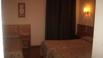 Quarto com duas camas, cabeceira de madeira, mesa de cabeceira, luminária na parede e um quadro emoldurado.
