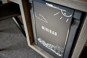 Obra de arte emoldurada com o texto "MINIBAR" e um desenho de uma cidade.