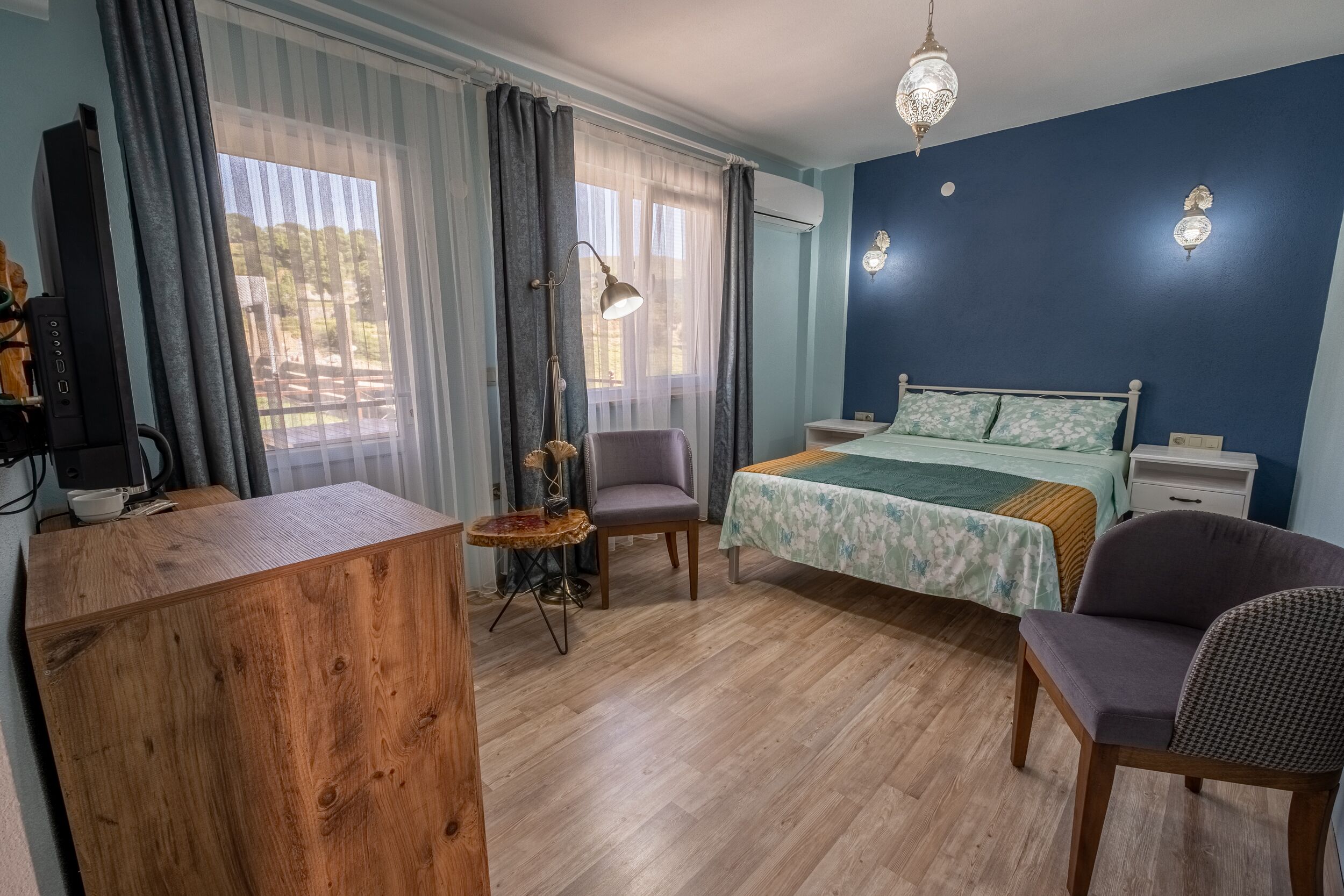 Quarto com cama, escrivaninha, cadeira, mesinha e abajur.