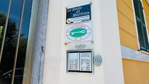 Canto de um edifício com placa indicando 'Le Stelle di Martina' e sinalização de 'AFFITTACAMERE', indicando acomodação para aluguel.
