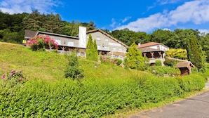 Um hotel com vários edifícios numa encosta, rodeado por vegetação exuberante e árvores.