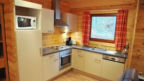 Cozinha compacta com micro-ondas, fogão, forno e lava-louças.